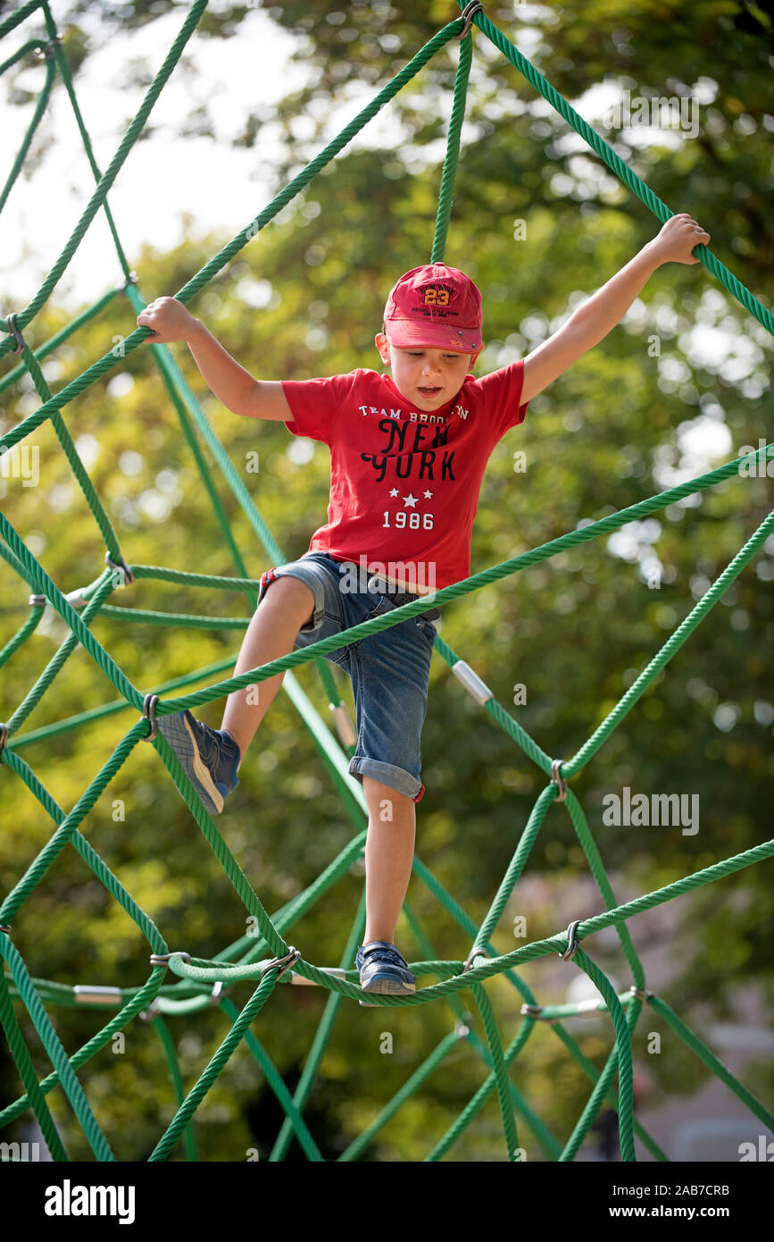 Young boy climbing on a spider web Stock Photo - Alamy