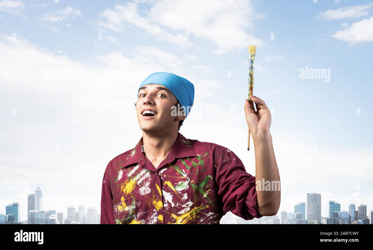 Smiling young painter artist pointing upwards Stock Photo - Alamy