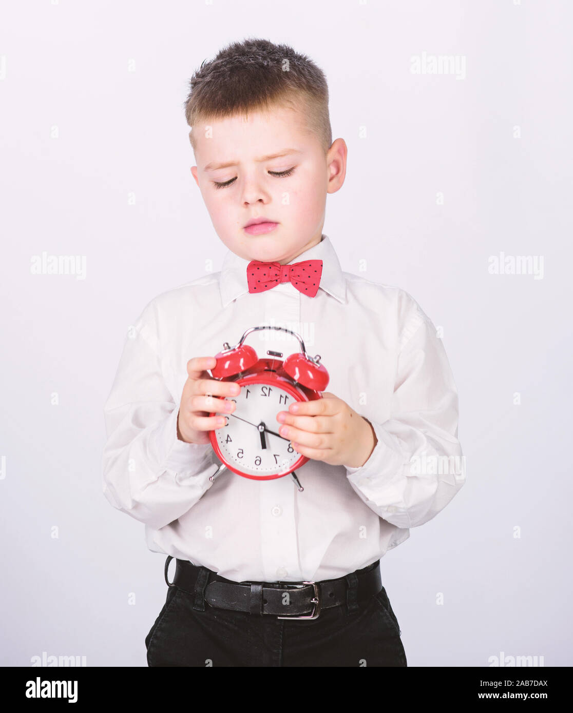 Develop self discipline. Set up alarm clock. Child little boy hold red ...