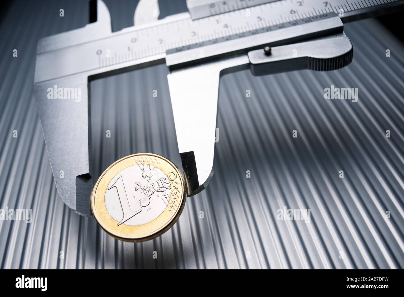 metal gauge measuring a one euro coin on a metal surface Stock Photo ...