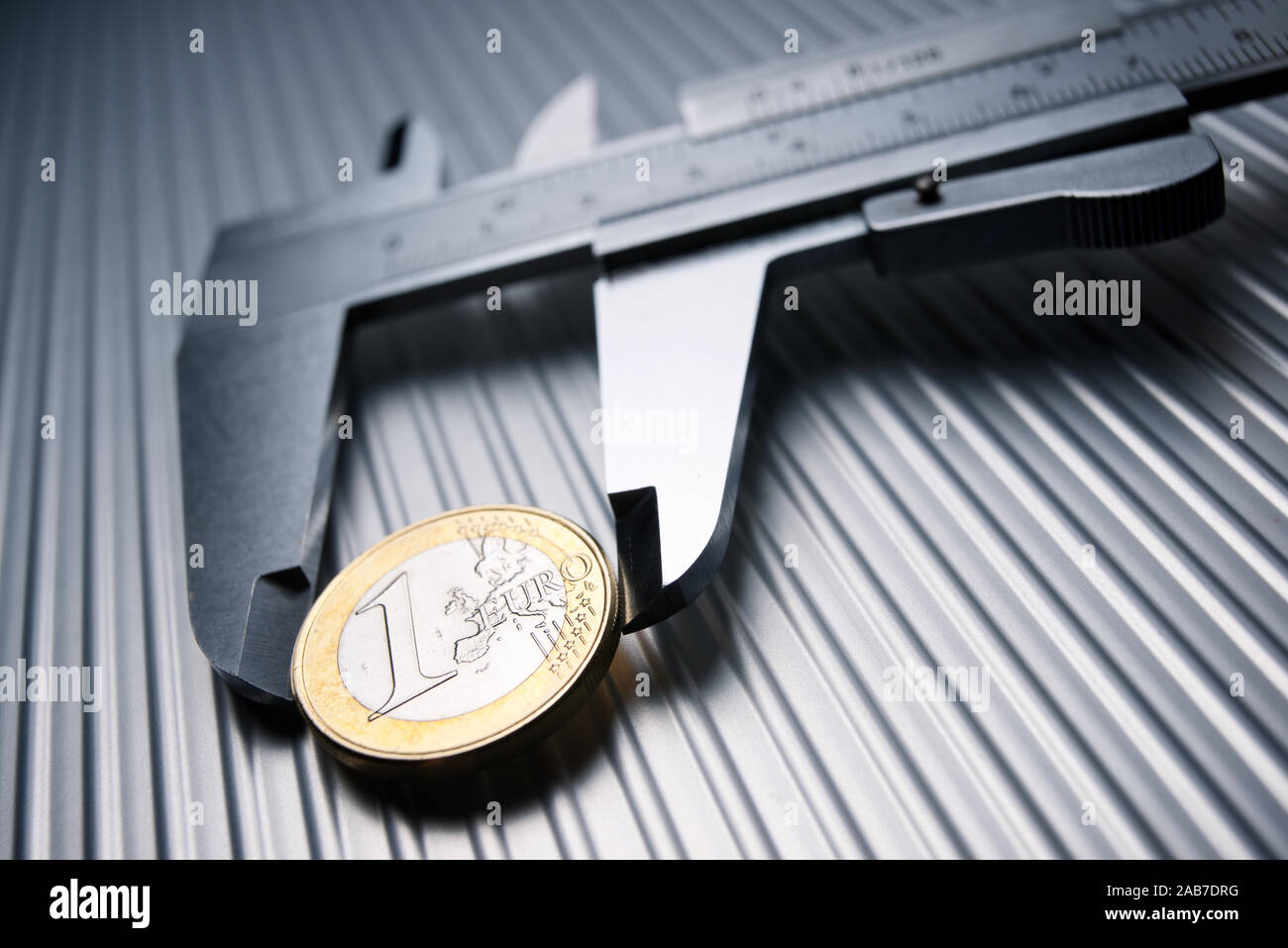 metal gauge measuring a one euro coin on a metal surface Stock Photo ...