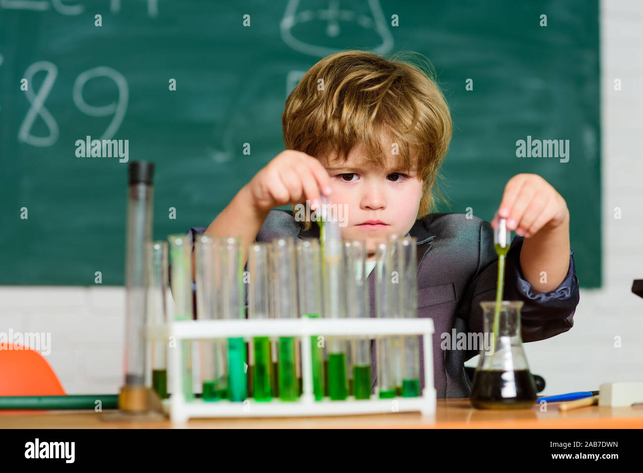 small boy using microscope at school lesson. small boy at science camp ...