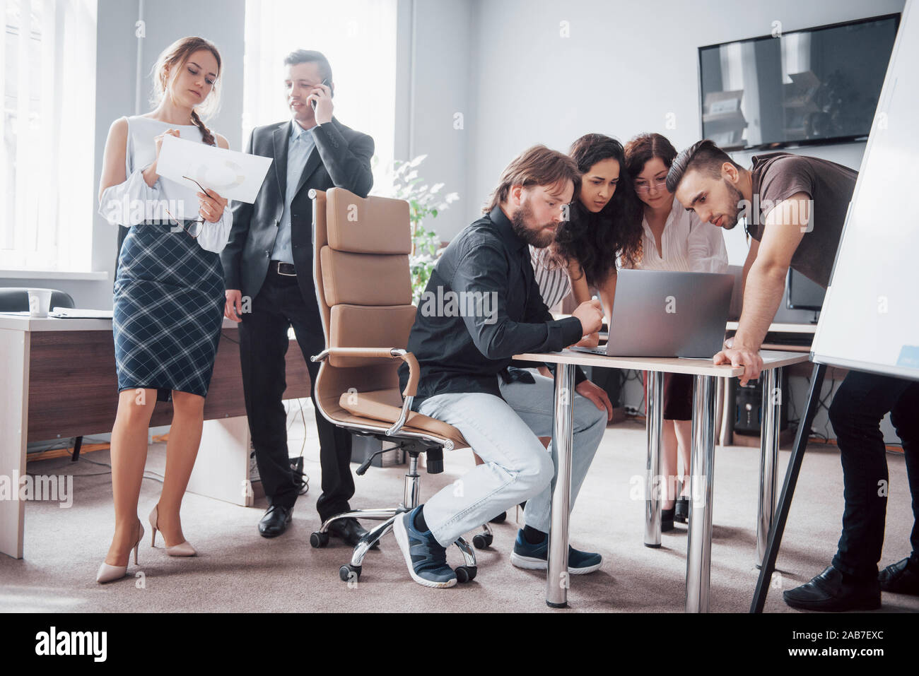 Colleagues communicate with work questions in modern office space Stock ...