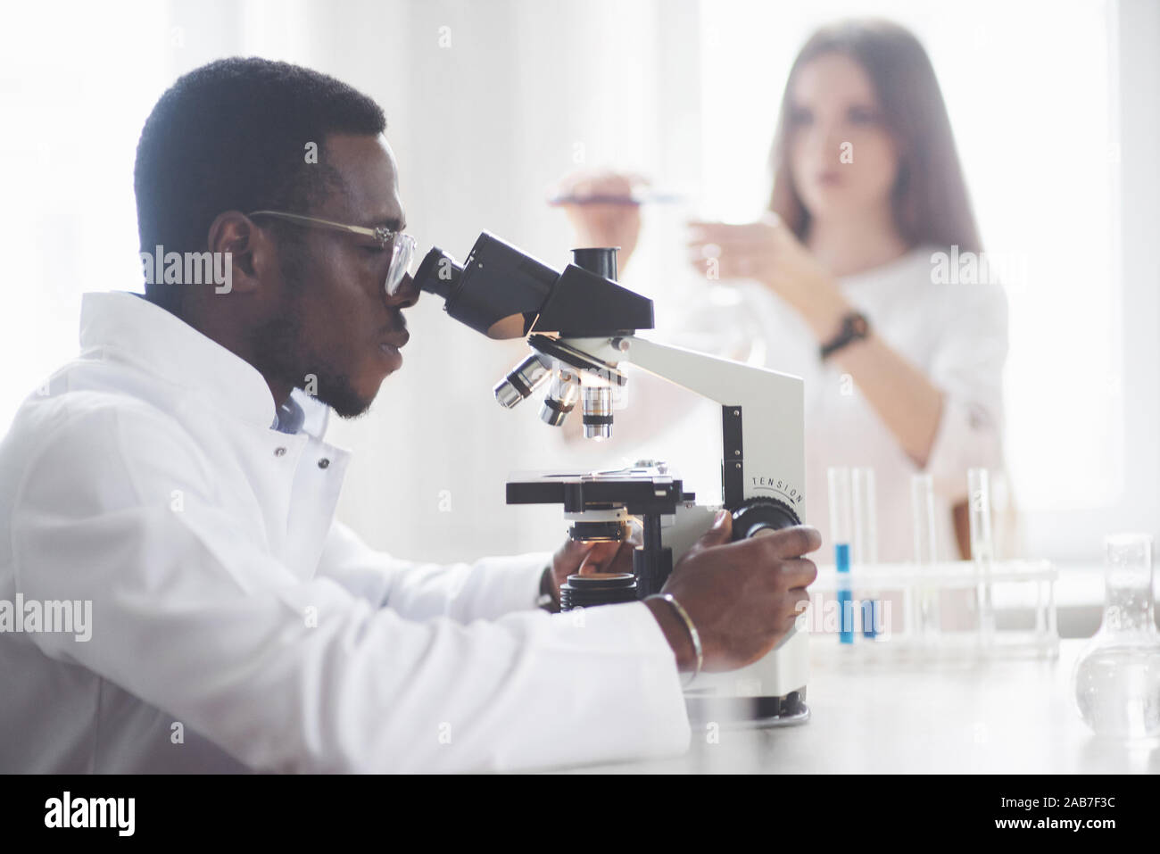 The scientist works with a microscope in a laboratory conducting ...