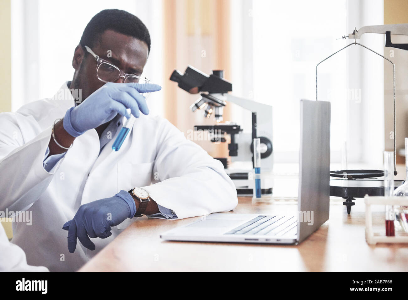 An African American worker works in a laboratory conducting experiments ...