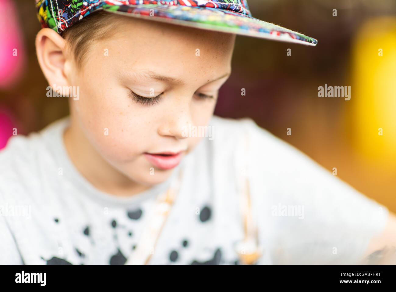 A handsome little boy with ADHD doing his homework, holding a pen while ...