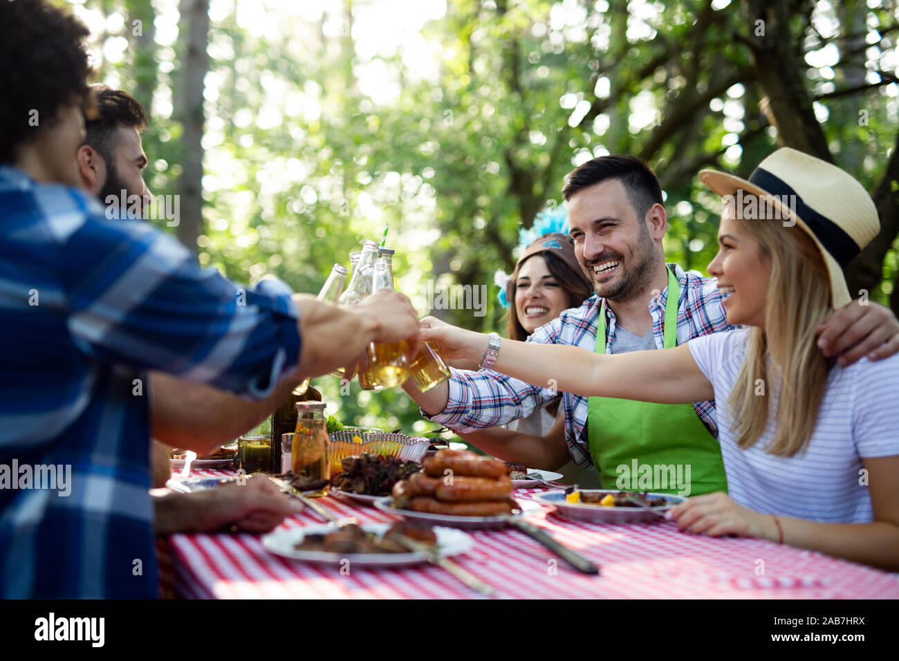 Group of happy friends eating and toasting at garden barbecue Stock ...