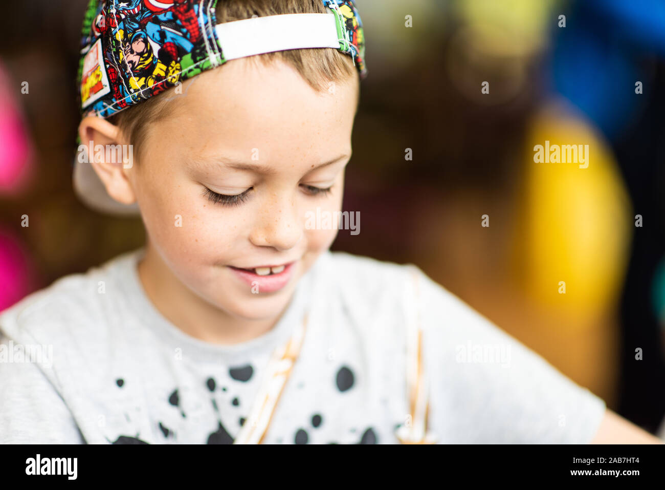 A handsome little boy with ADHD doing his homework, holding a pen while ...