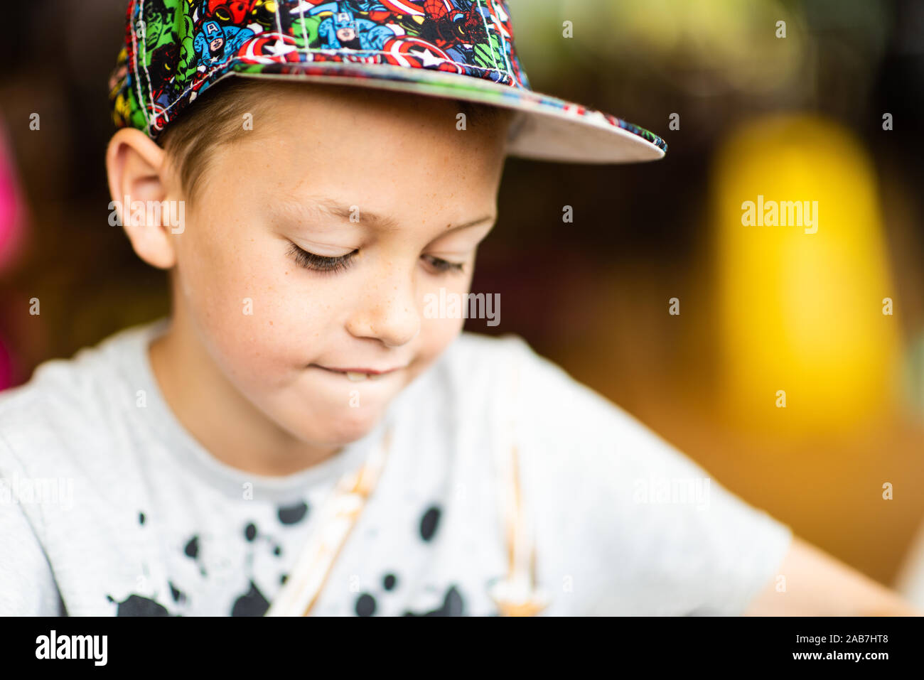 A handsome little boy with ADHD doing his homework, holding a pen while ...