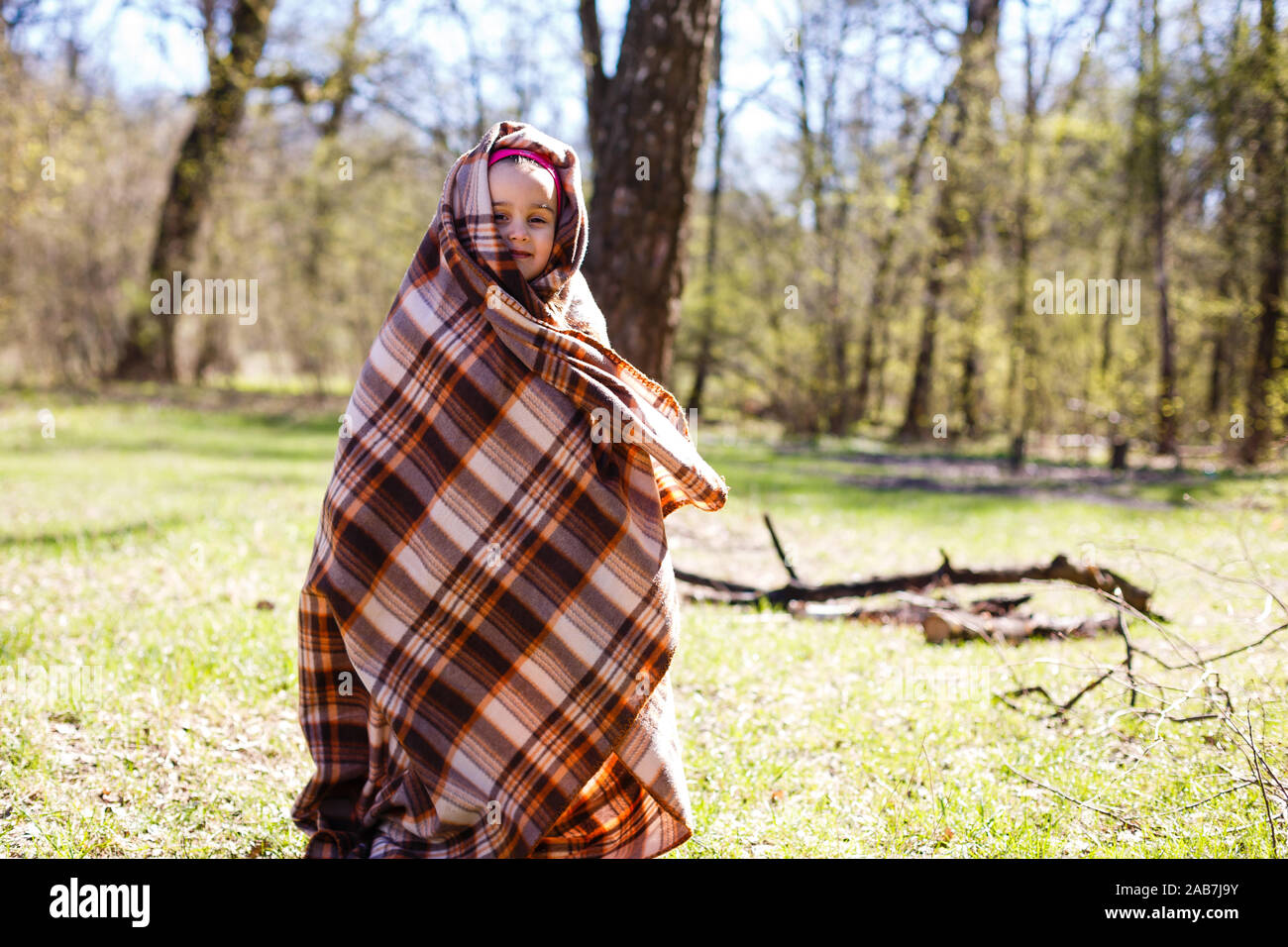 Cute twin sisters wrapped in check plaid. Colorful autumn park. Little ...