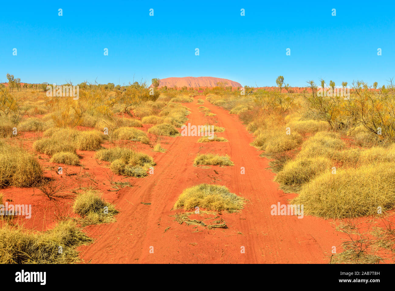 Red sand path in dry bush landscape in Australian Outback with Ayers ...