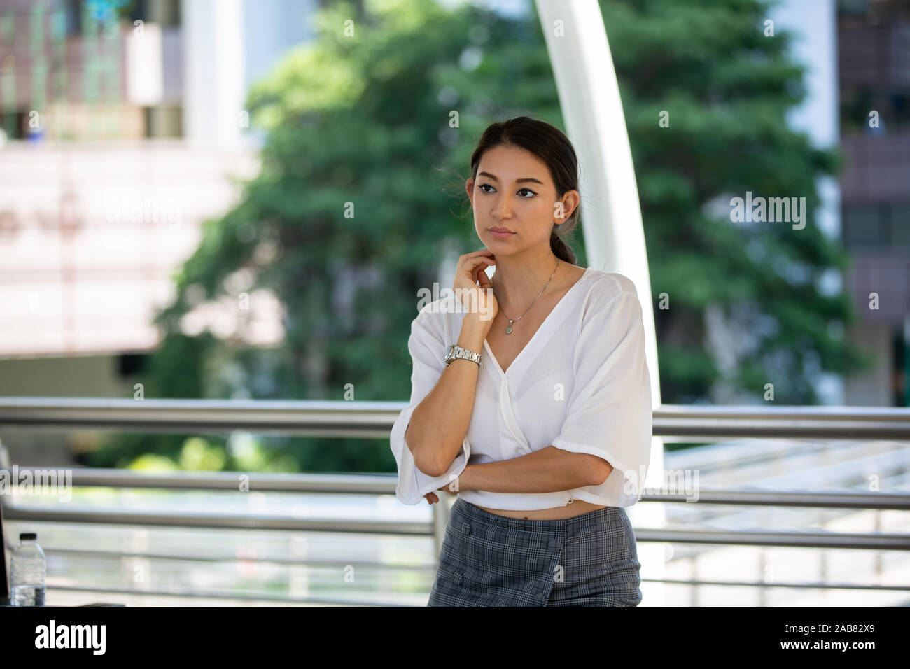Portrait of young beautiful business woman at outside. Crossed arms ...