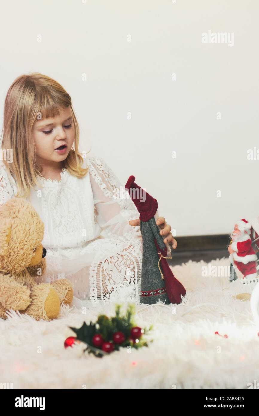 Cute little blond girl sitting on the floor, playing with her teddy ...