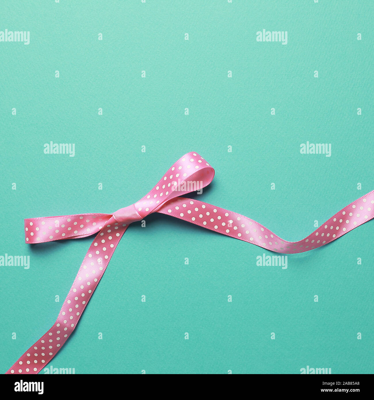 Decorative pink bow ribbon on mint background Stock Photo - Alamy