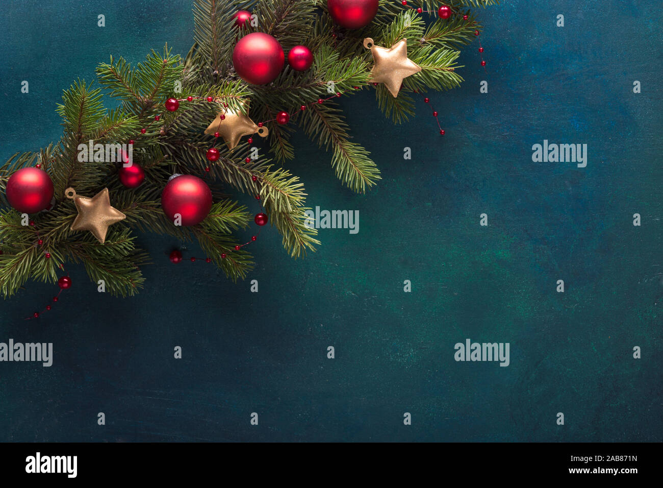 Fir branch with Christmas decoration on a dark blue-green painted ...