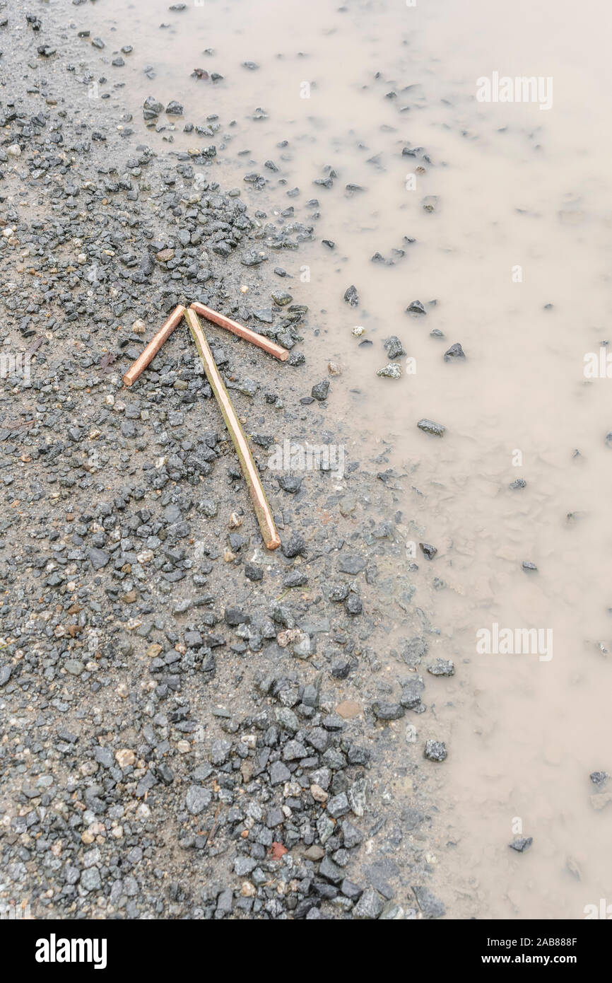 Survival skills concept. Signal arrow on gravel 'proceed this way ...