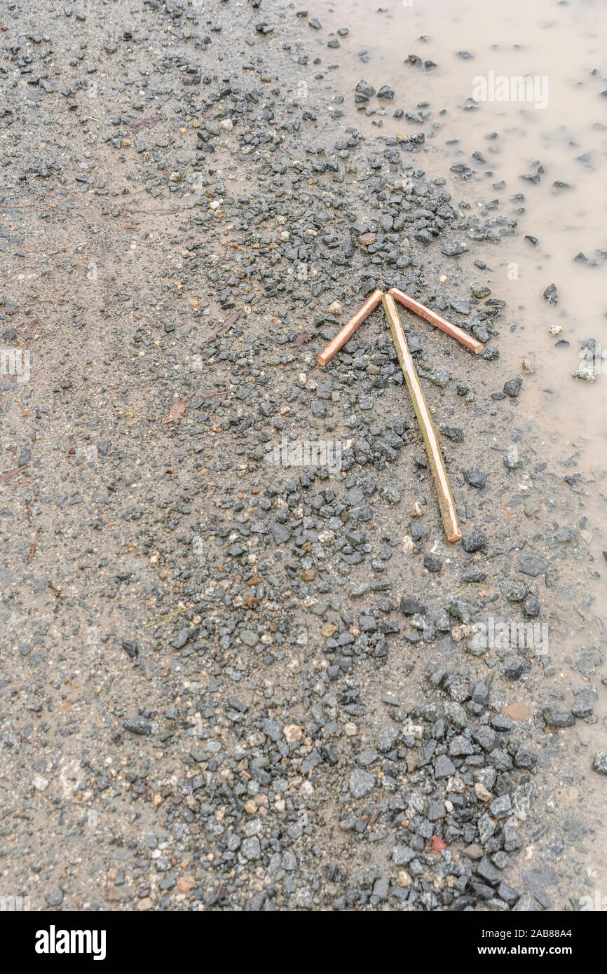 Survival skills concept. Signal arrow on gravel 'proceed this way ...