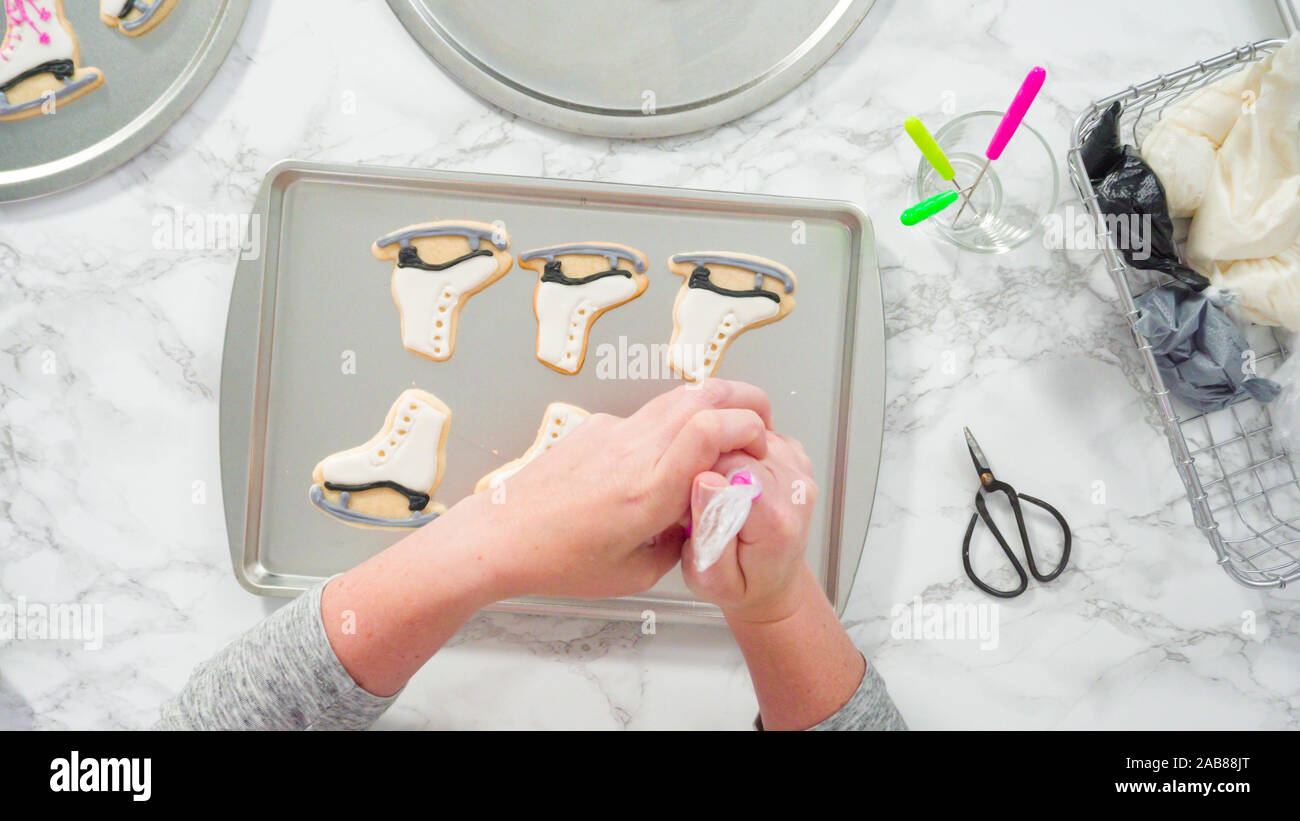 Flat lay. Icing figure skate shaped sugar cookies with royal icing ...
