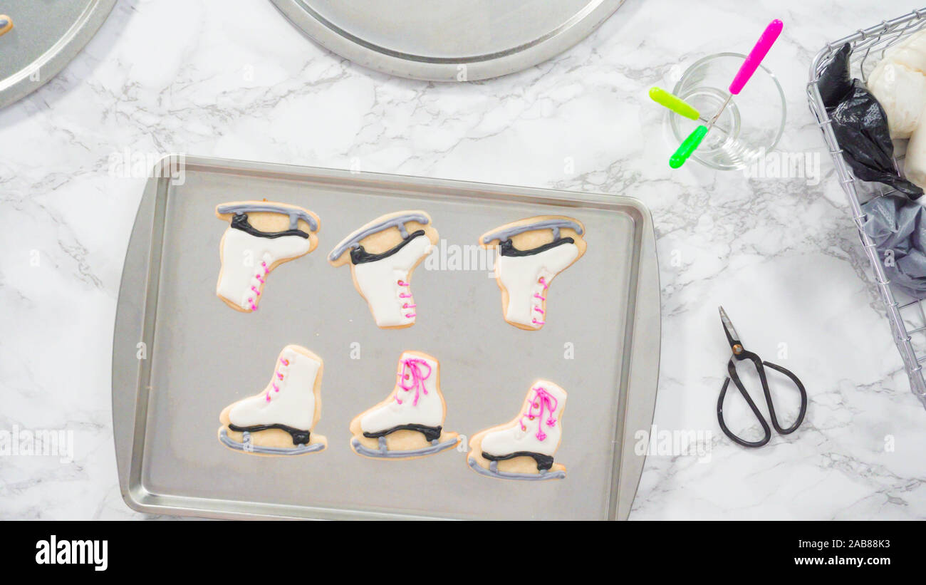 Flat lay. Icing figure skate shaped sugar cookies with royal icing ...