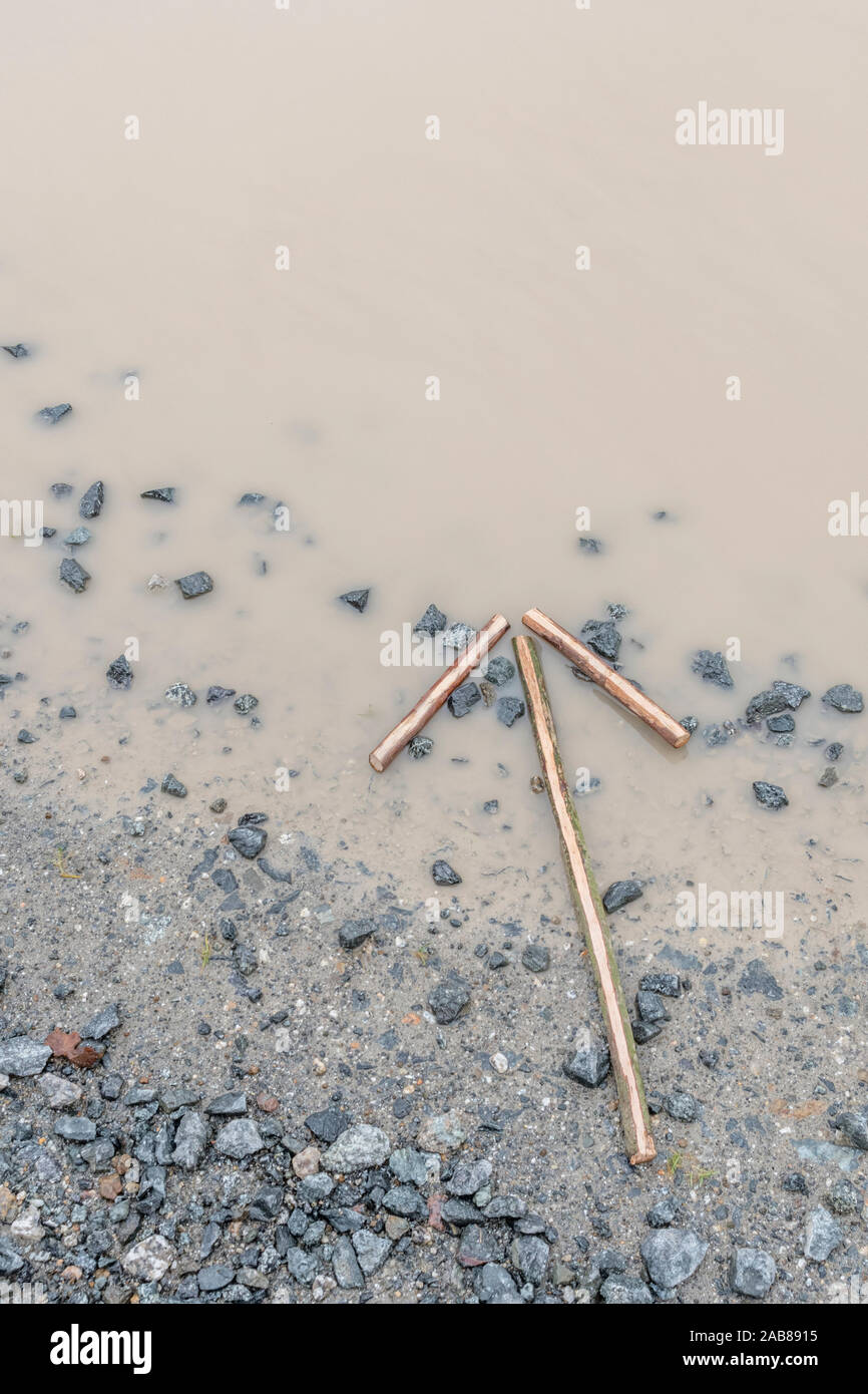 Survival skills concept. Signal arrow on gravel 'proceed this way ...