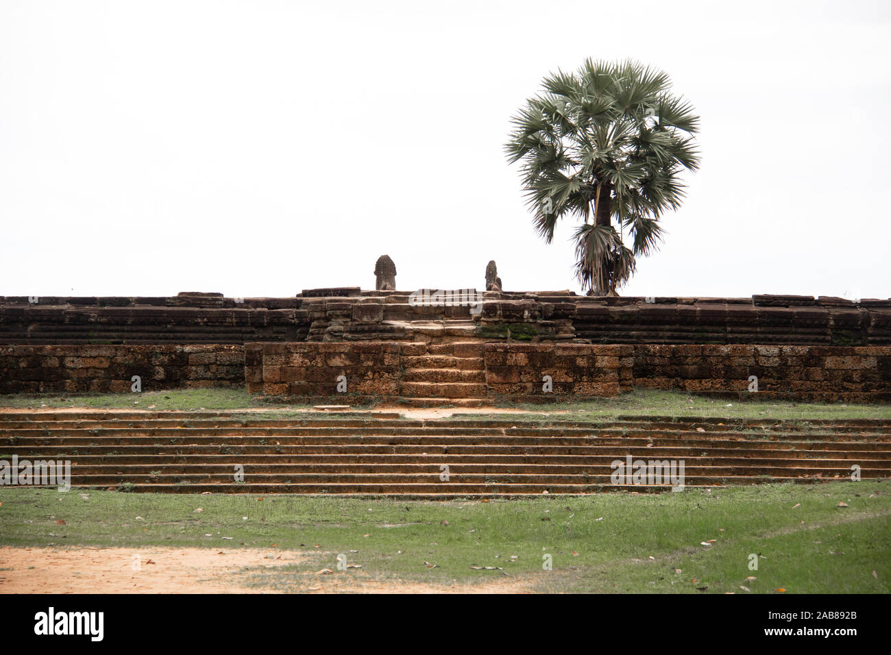 Old red stone stairs leading to a platform with a palm on the right, at ...