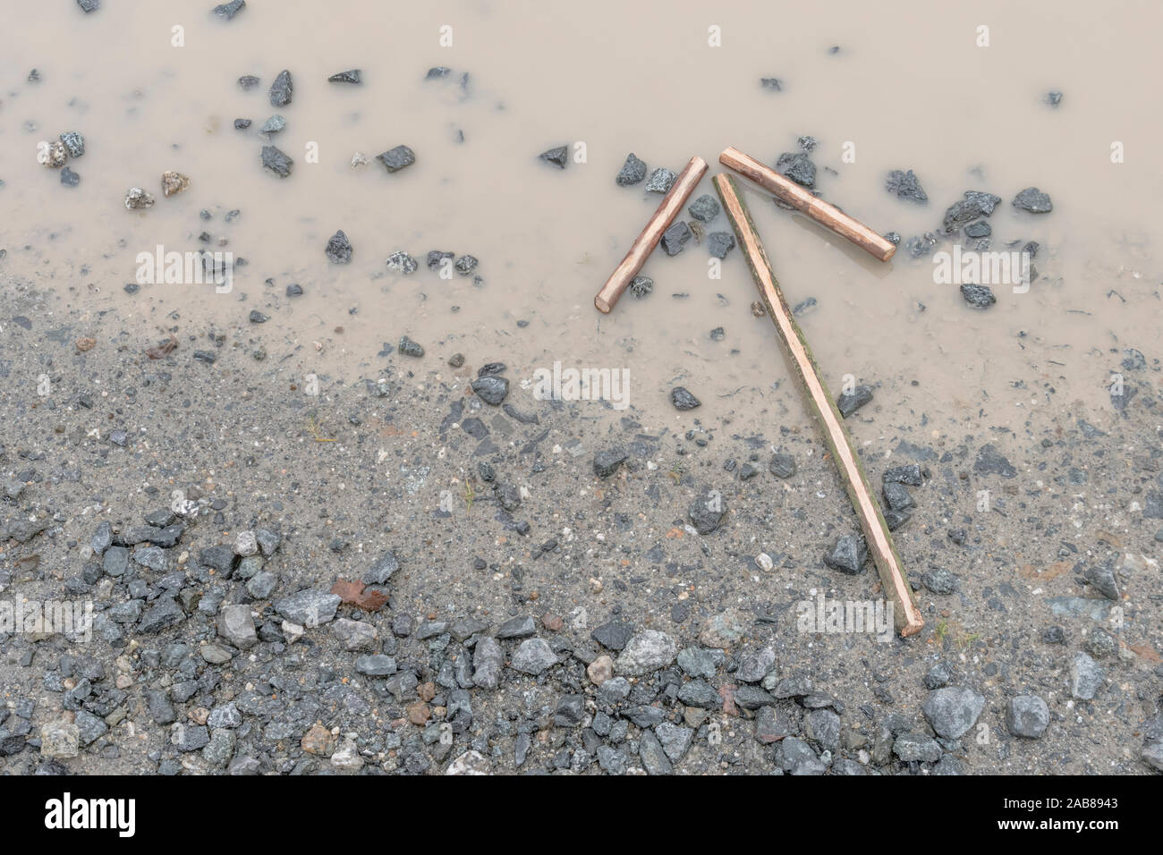 Survival skills concept. Signal arrow on gravel 'proceed this way ...