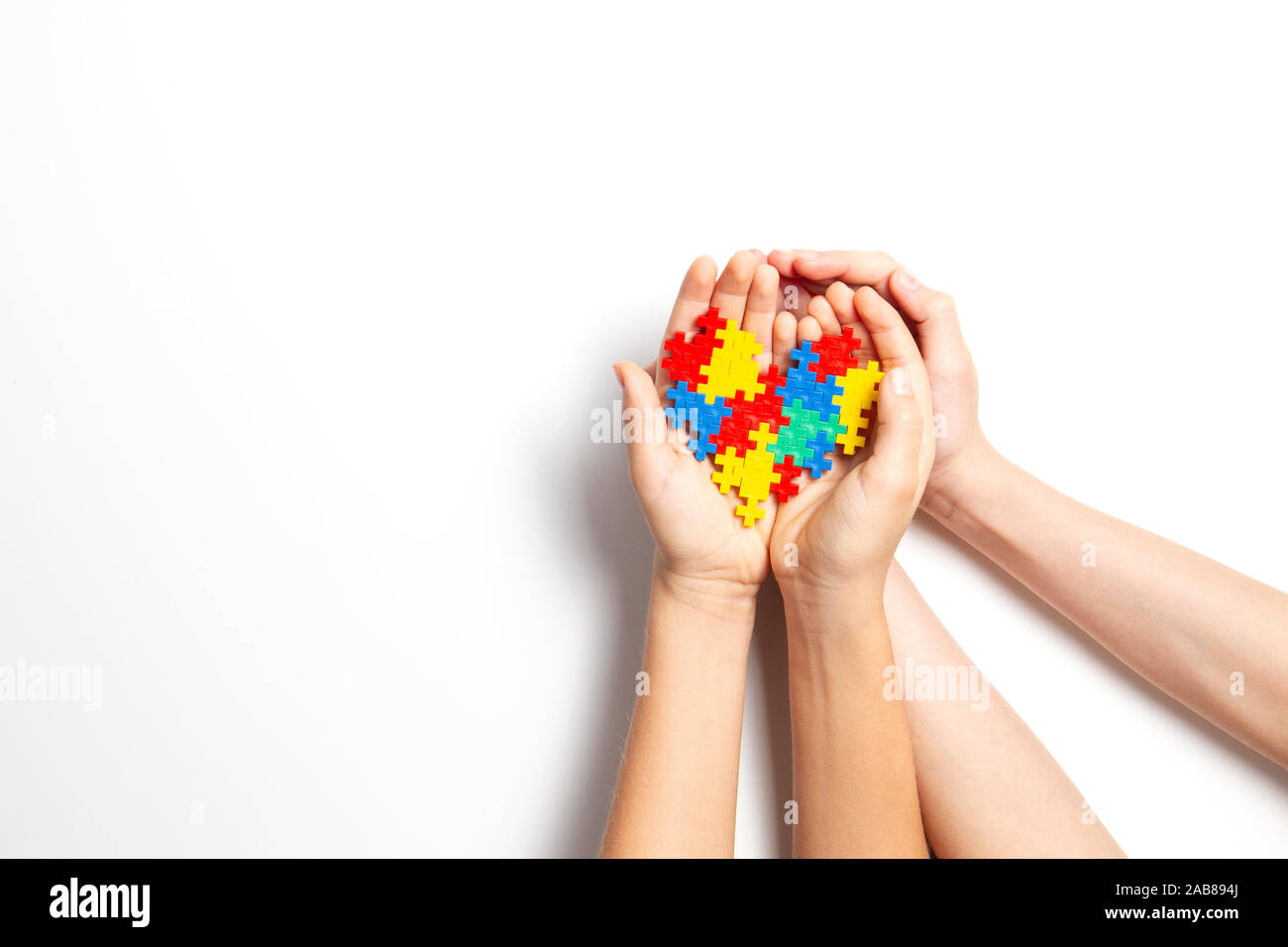 Hands holding colorful heart on white background. World autism ...