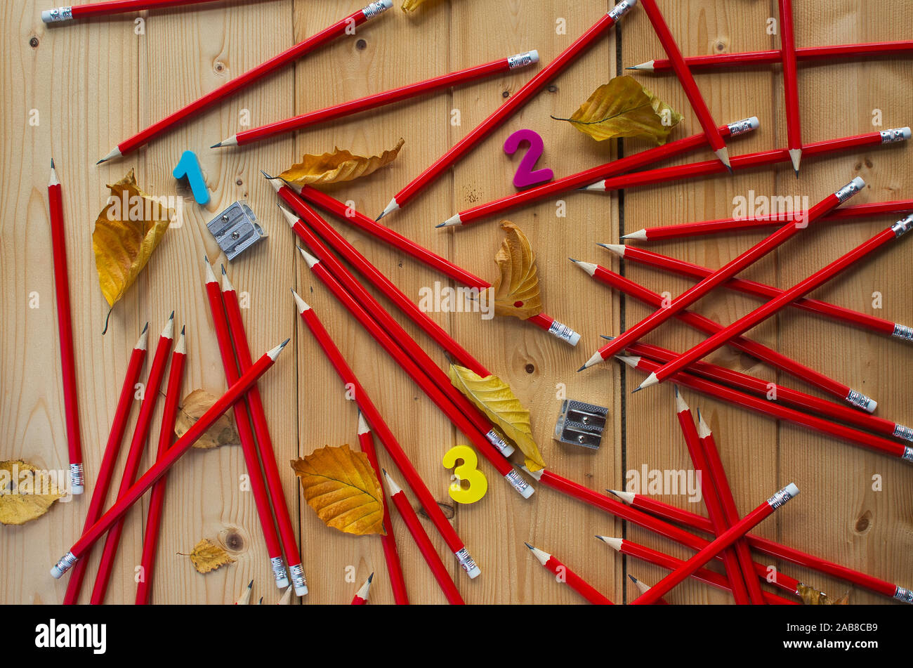 Set of red graphite pencils,colorful numbers and shapeners on wood ...