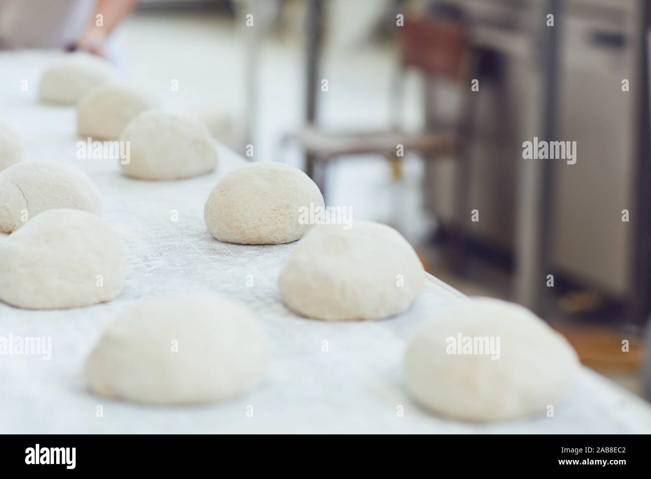 Raw bread on trays before baking at the bakery Stock Photo - Alamy