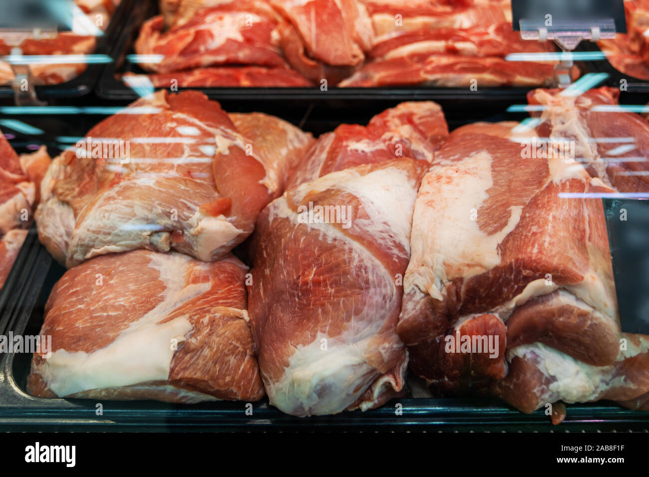 Selection of quality meat at a butcher shop, refrigerated display in ...