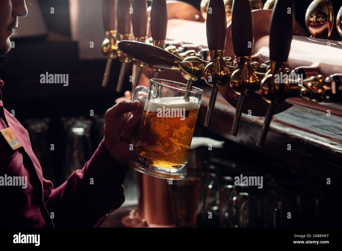 bartender fills beer mug from beer tap Stock Photo - Alamy