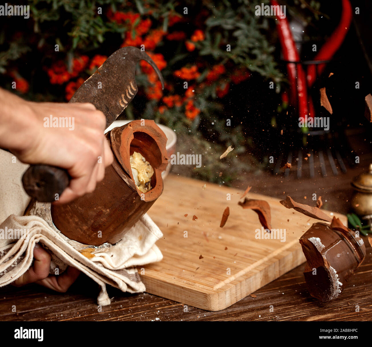 man breaking pottery jar filled with lamb stew Stock Photo - Alamy