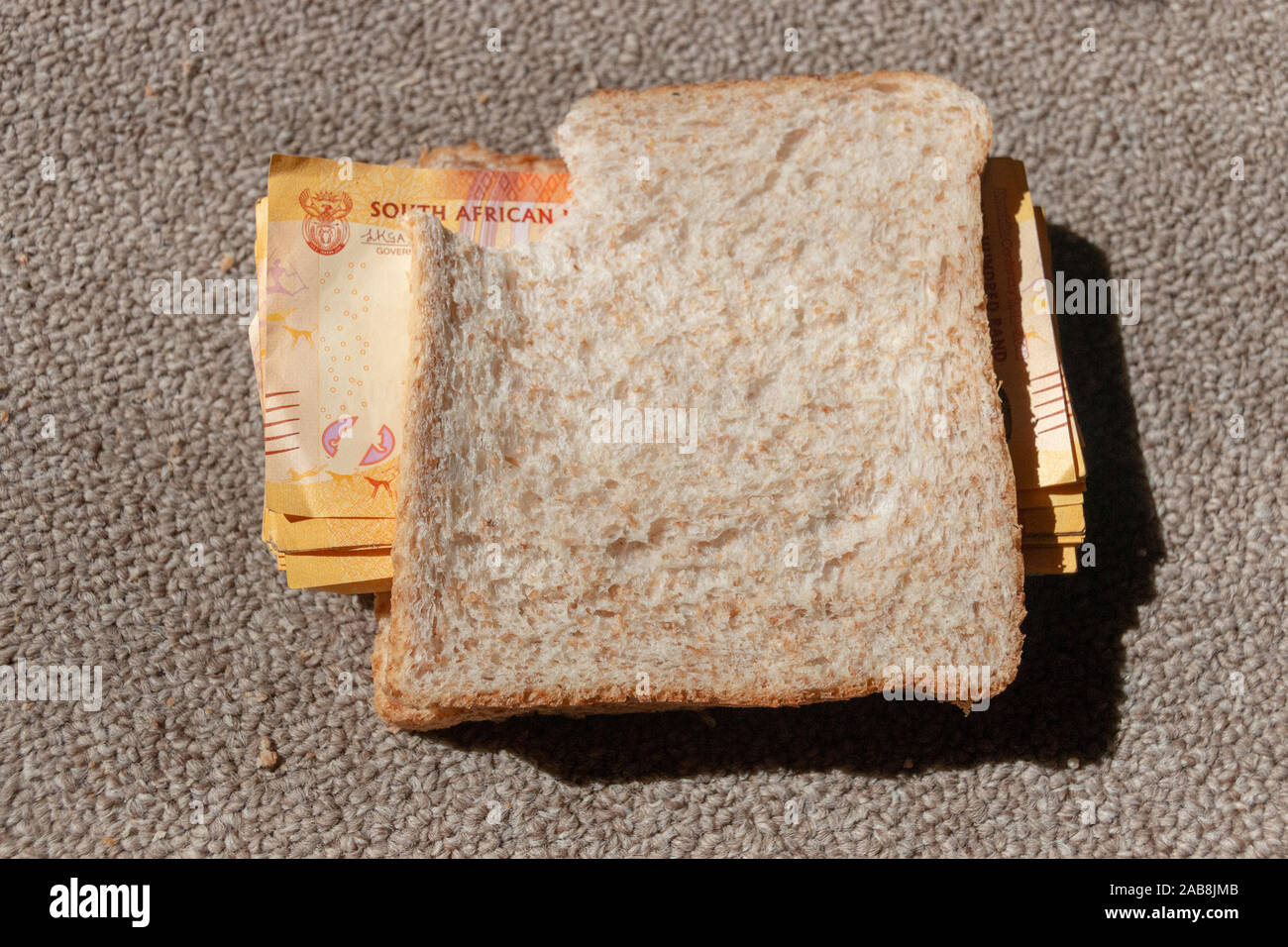 A close up view of one and two hundred rand notes in between a brown ...