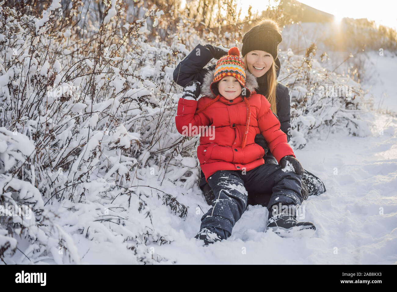 winter Mother and son throwing snowball at camera smiling happy having ...
