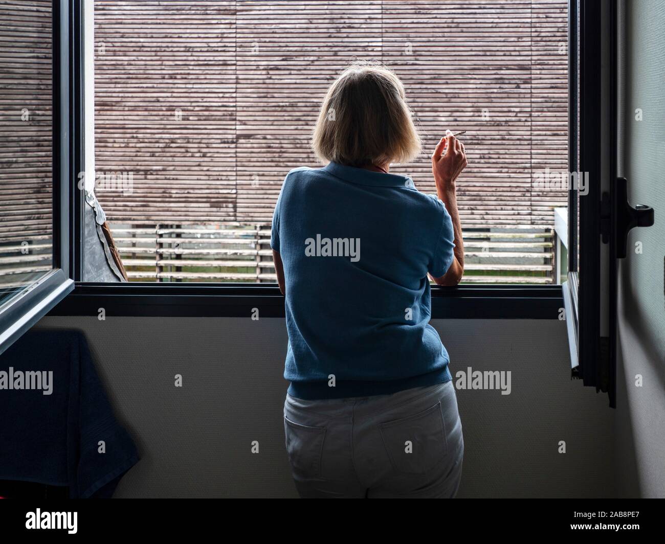 Senior woman looking through window hi-res stock photography and images ...