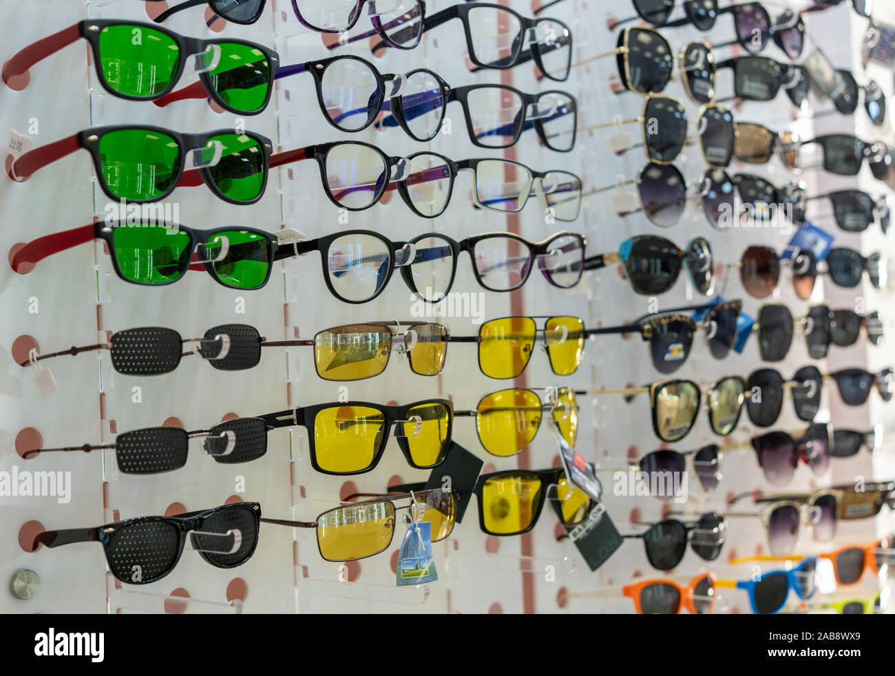A large assortment of different glasses on a shelf in an optics store ...