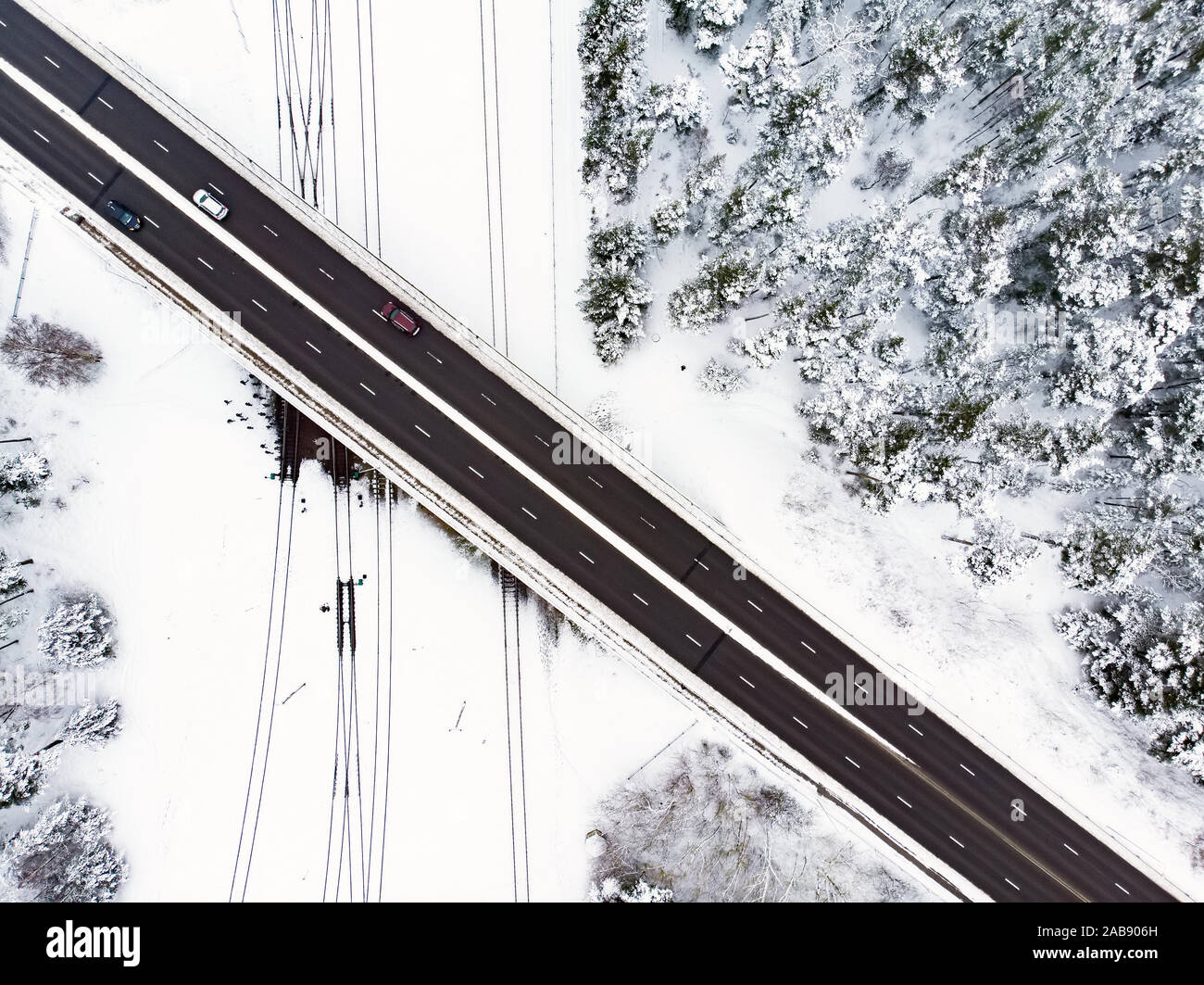 Beautiful aerial view of snow covered fields with a two-lane road among ...