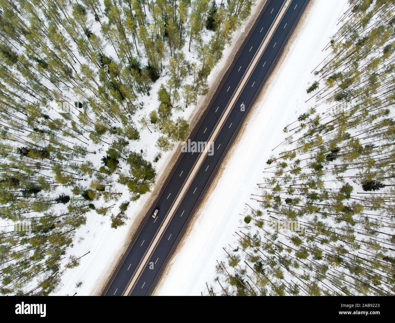 Beautiful aerial view of snow covered fields with a two-lane road among ...