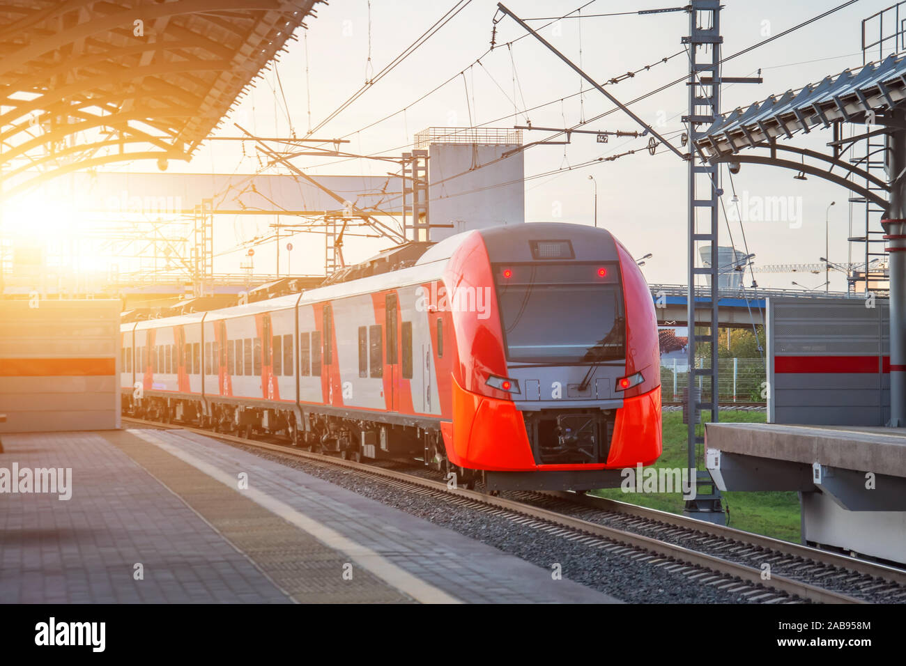 Passenger electric train departs from the station platform and rides on ...