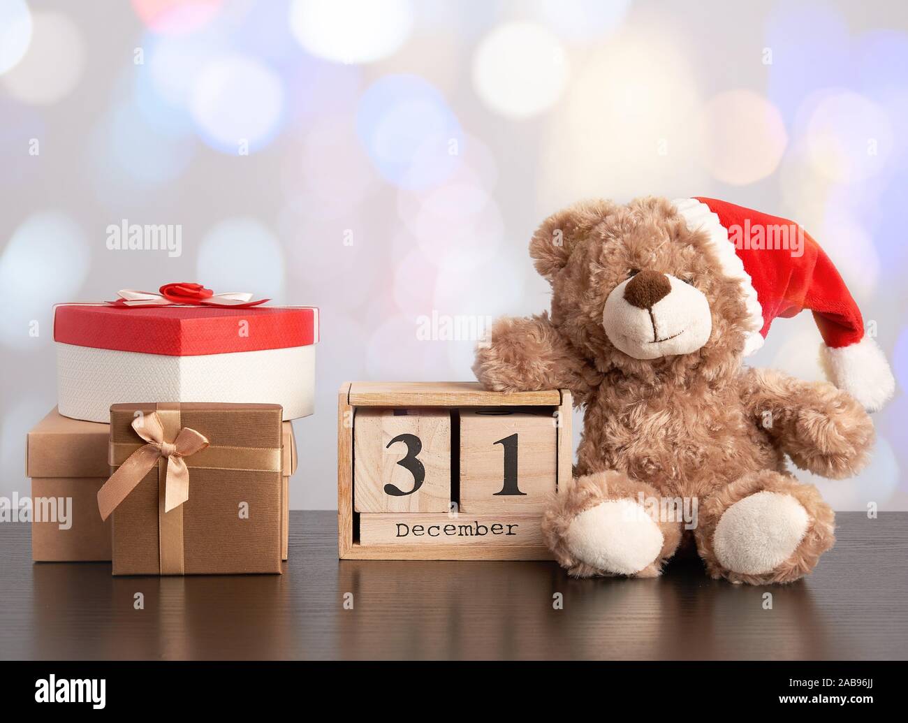 brown teddy bear and a stack of various cardboard boxes for gifts on a ...