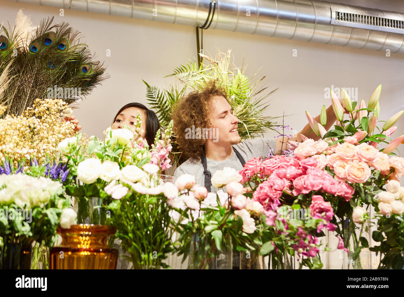Florist team in flower shop between selection of colorful flowers Stock ...