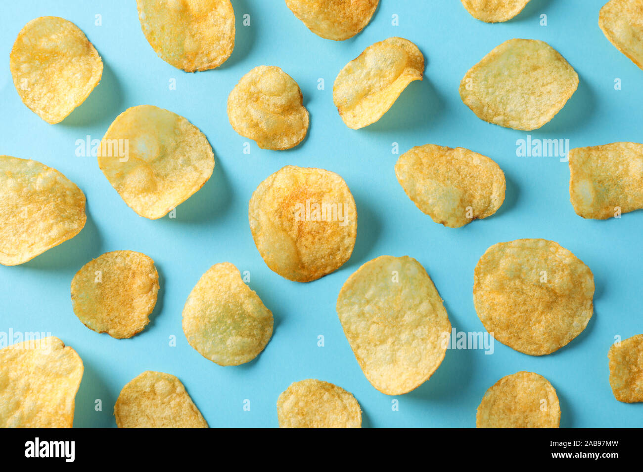 Flat lay composition with potato chips on blue background, top view ...