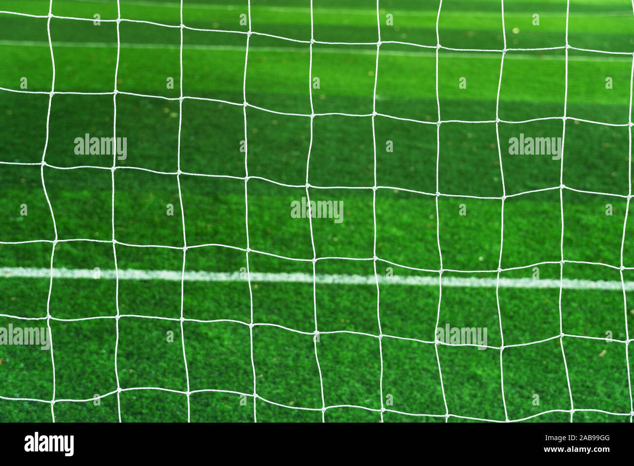 white net football or soccer goal and green grass competition field ...