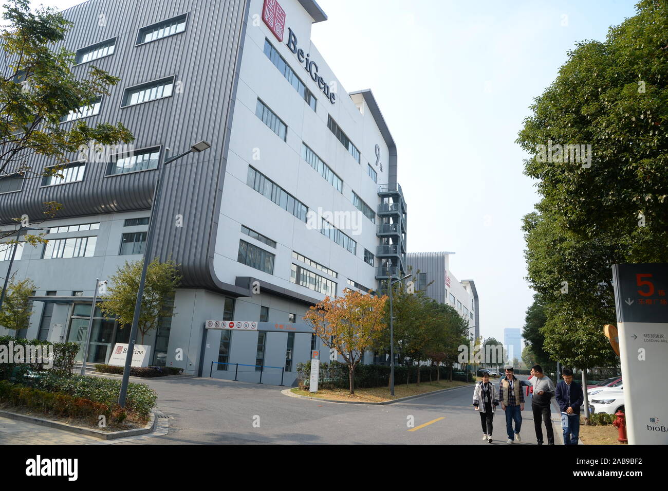Pedestrians walk past the office building of Chinese pharmaceutical ...