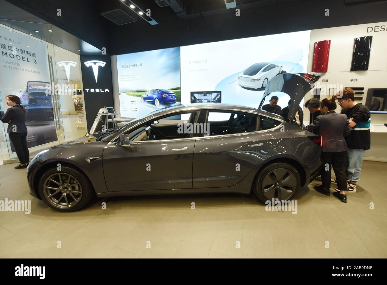 People look at a Chinese-manufactured Tesla Model 3 electric car on ...