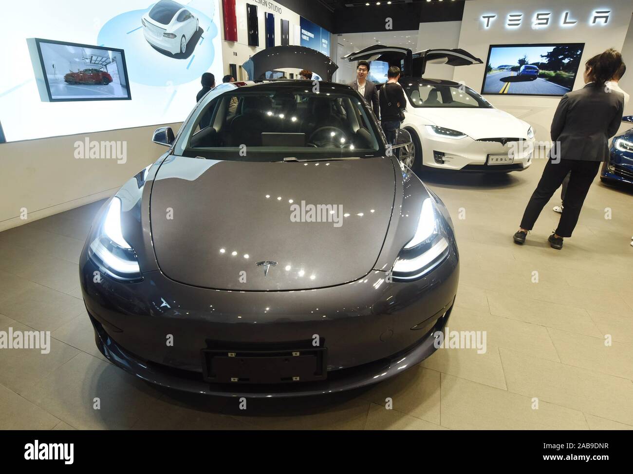 People look at a Chinese-manufactured Tesla Model 3 electric car on ...
