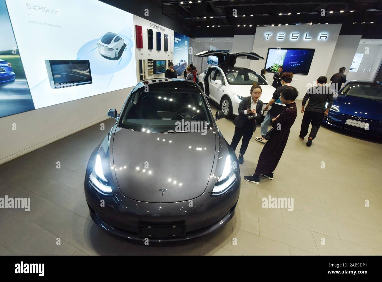 People look at a Chinese-manufactured Tesla Model 3 electric car on ...