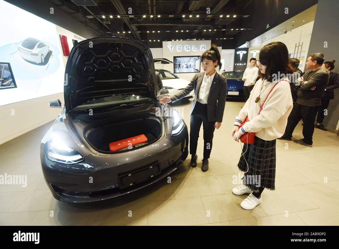 People look at a Chinese-manufactured Tesla Model 3 electric car on ...