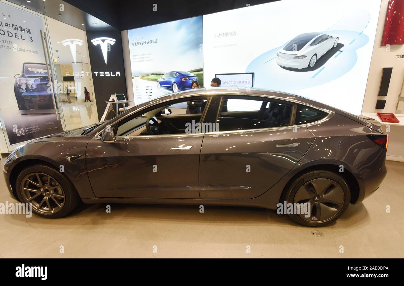 People look at a Chinese-manufactured Tesla Model 3 electric car on ...