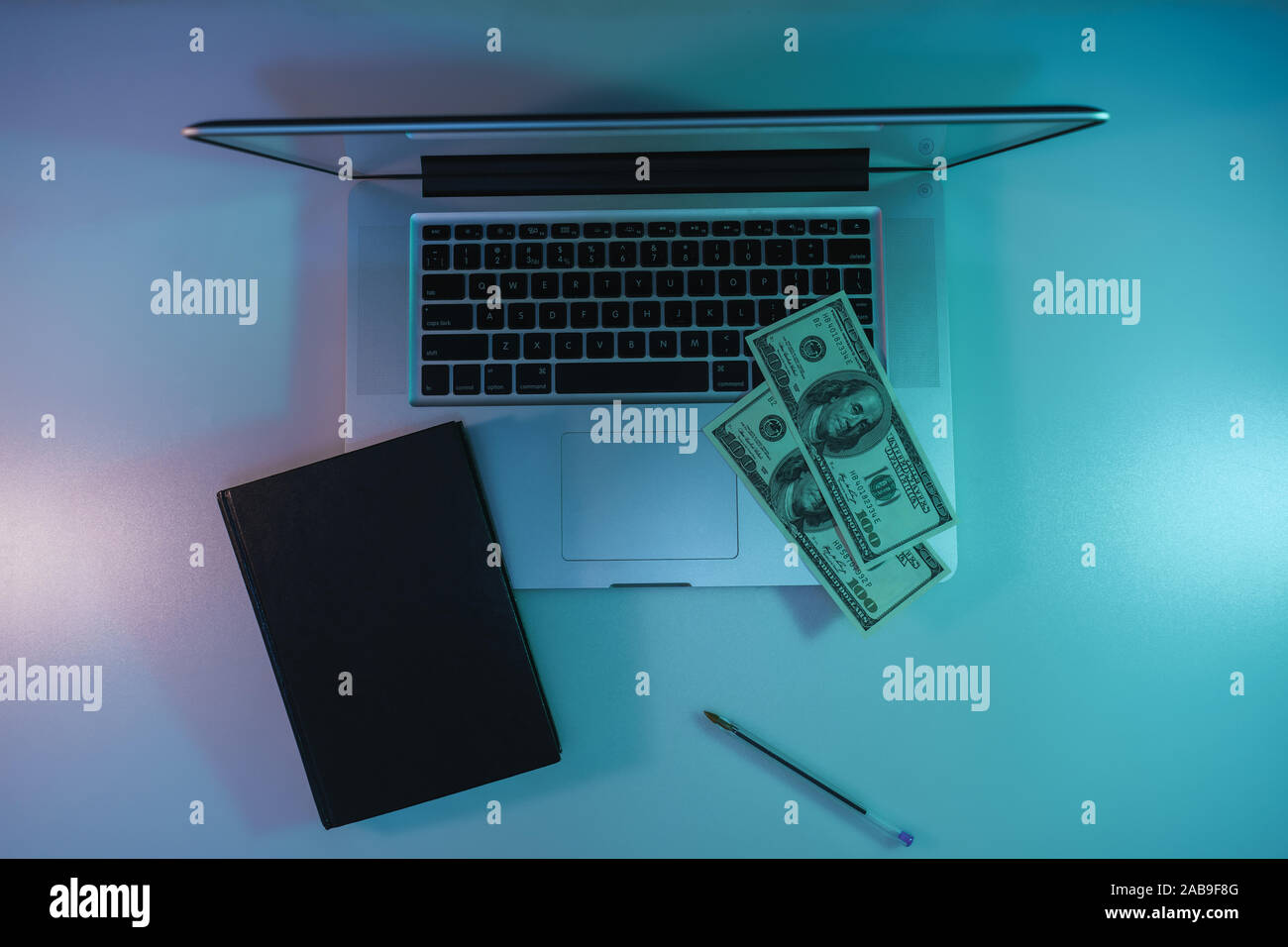 Beautiful silver laptop, notebook and cash dollars banknote in the ...